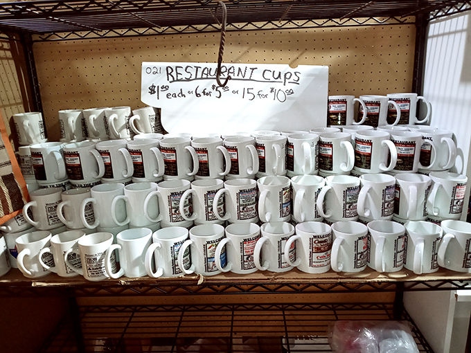 Restaurant mugs stacked with military precision—each one a refugee from some diner's going-out-of-business sale, now seeking a second chance.