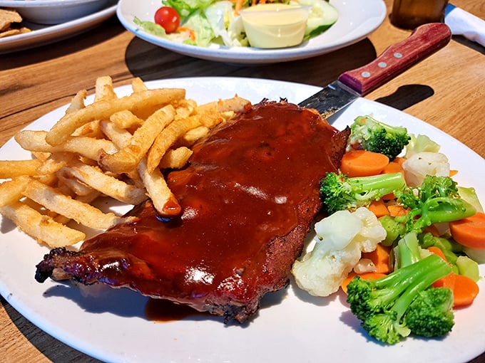 BBQ ribs so tender they practically file a flight plan off the bone, served with crispy fries and fresh veggies for that perfect balance of indulgence and virtue.
