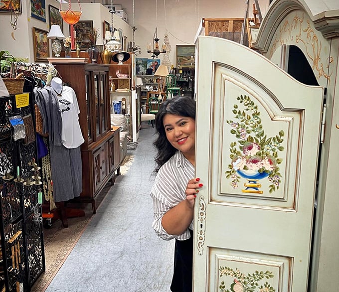 The thrill of discovery is written all over this shopper's face as she peeks around a beautifully painted vintage screen.