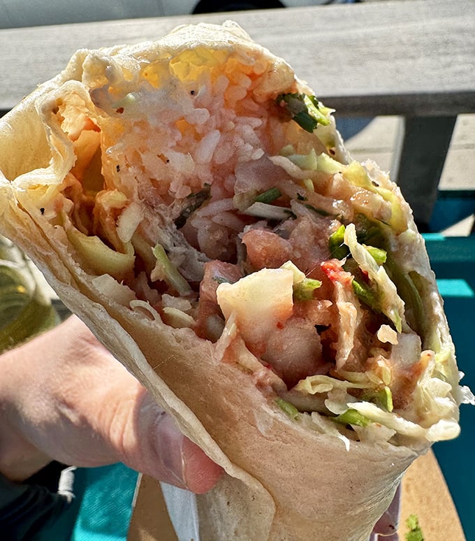 Peek inside this handheld treasure and discover why people drive for hours – layers of perfectly cooked seafood, crisp vegetables, and that legendary Spencer Sauce.