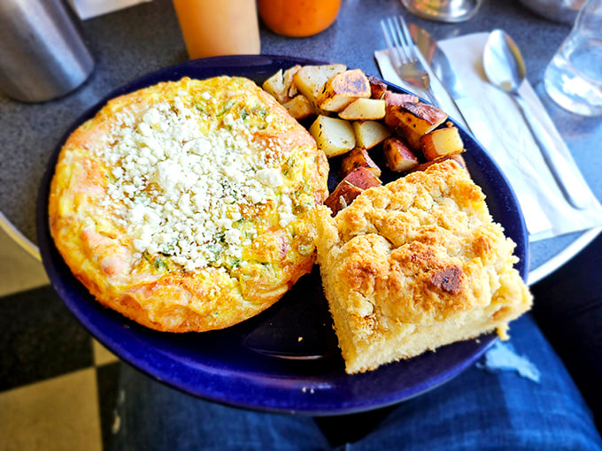 A frittata that could end wars – golden, cheese-topped perfection alongside home fries and cornbread that demands to be savored, not just eaten.