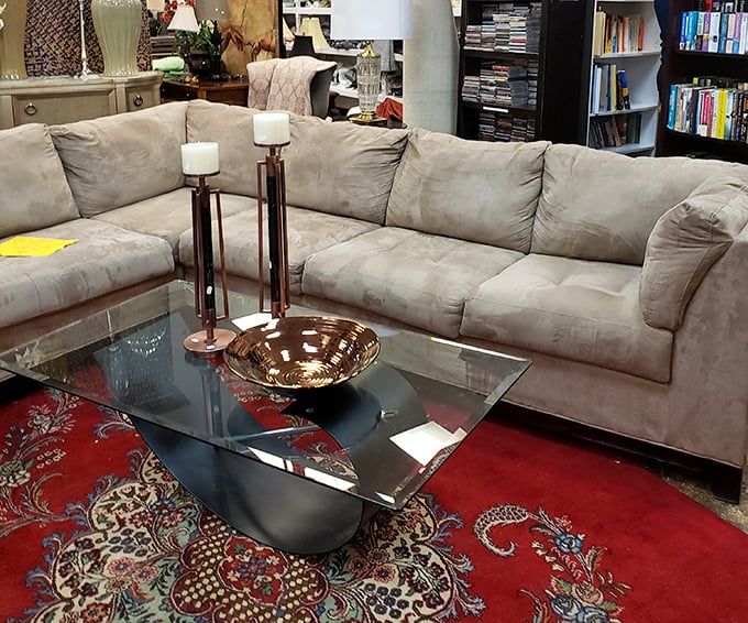 A neutral sectional anchored by a bold red rug—proof that secondhand furniture can look first-class in your living room.