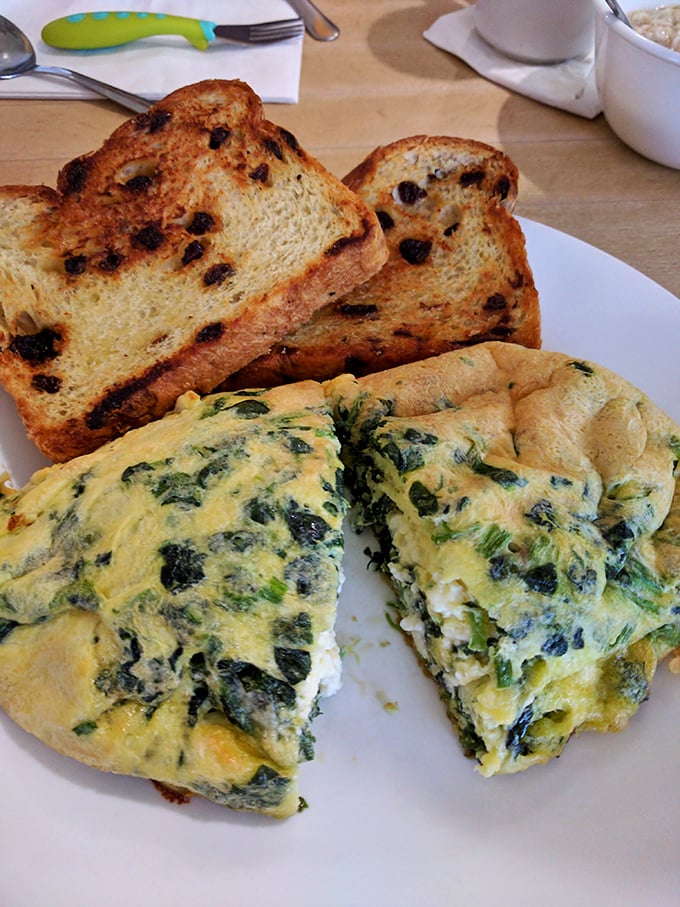 A spinach omelet that Popeye would approve of, paired with raisin toast that somehow makes eating vegetables before noon completely acceptable.