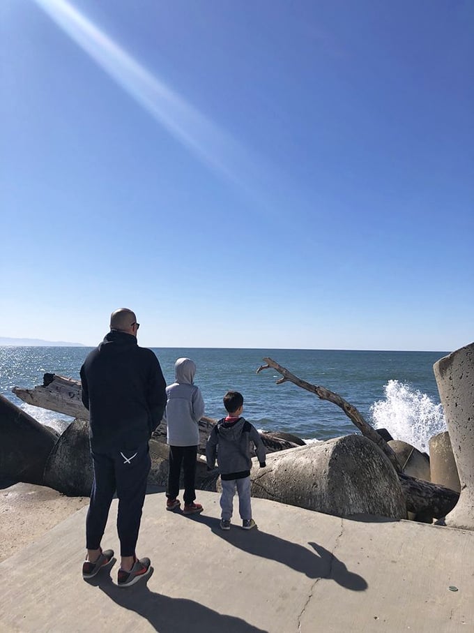 Families find their perfect vantage point along the jetty, where the drama of crashing waves meets the safety of solid ground.