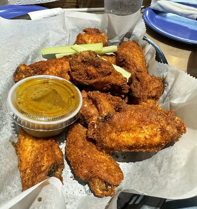 These wings aren't just crispy—they're the kind that make conversation stop mid-sentence. Served with celery sticks for that token vegetable gesture.
