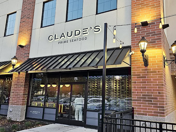 Claude's elegant brick exterior glows at twilight – sophisticated seafood awaits behind those warm, welcoming lights.