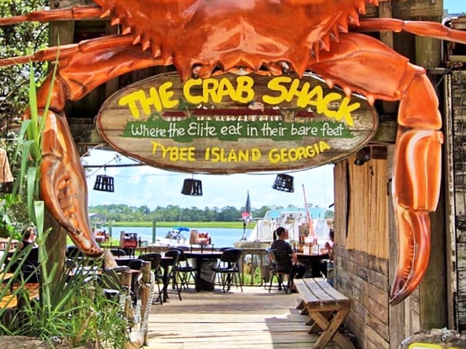 The Crab Shack's giant crustacean guardian announces: "Where the elite eat in their bare feet" – coastal dining perfection!