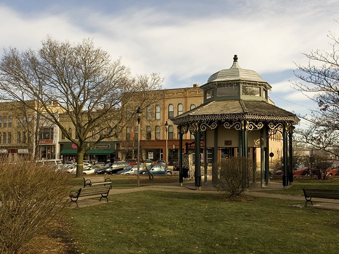 Woodstock's gazebo stands like a Victorian gentleman in a modern world, tipping its metal hat to passersby while brick buildings applaud in the background.
