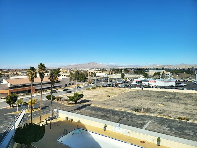 Victorville stretches toward distant mountains like a sunbather reaching for lotion—palm trees and empty pools hint at desert life's rhythms.