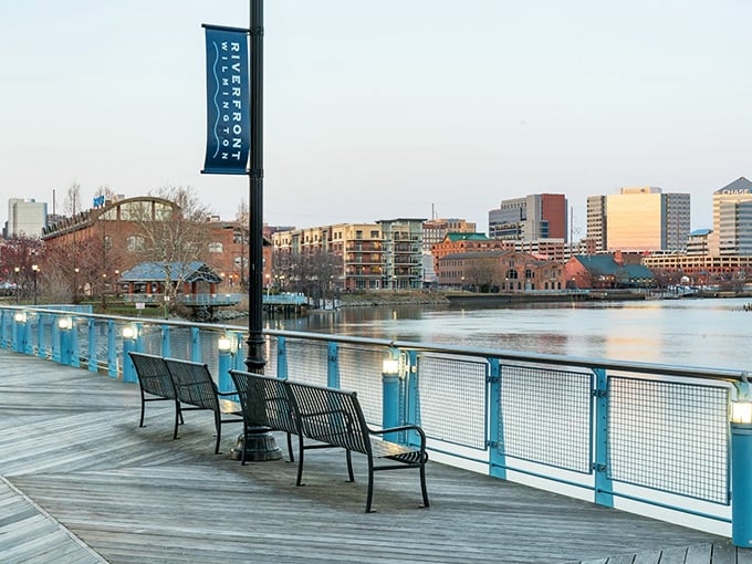 Riverfront benches offer front-row seats to city life where water meets downtown in peaceful coexistence.