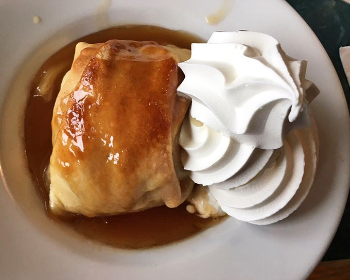 An apple dumpling that doesn't just satisfy your sweet tooth—it writes it a heartfelt thank-you note. That whipped cream crown is well-deserved.