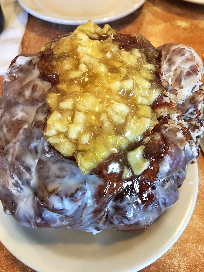 This apple fritter isn't just a pastry—it's architecture. A cathedral of glazed dough and cinnamon-spiced apples that demands reverent silence before the first bite.