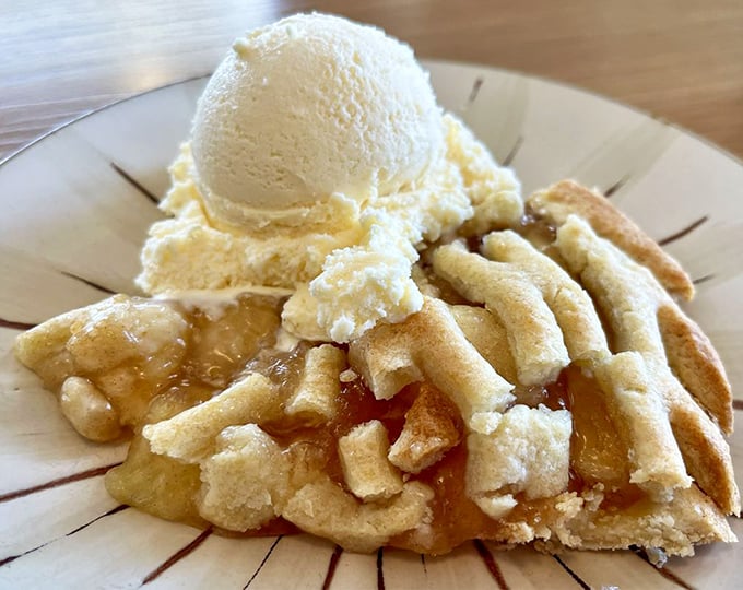 A slice of apple pie that whispers "à la mode" before you even think to ask, topped with ice cream melting into those warm cinnamon-spiced apples.
