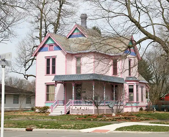 This cotton-candy pink Victorian house looks like it was plucked straight from a storybook, complete with gingerbread trim and wraparound porch.
