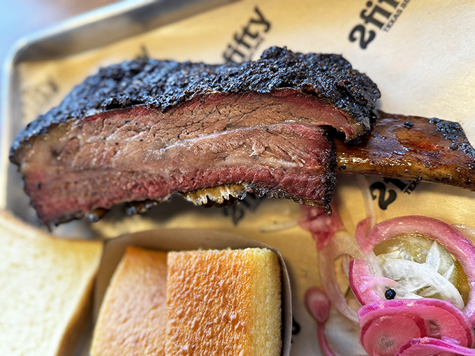 This beef rib isn't just dinner—it's Fred Flintstone's dream come true, with bark so perfect it deserves its own appreciation society.