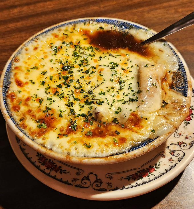 This isn't just onion soup—it's a bubbling cauldron of comfort, where cheese stretches like the stories of Paul Revere's ride.