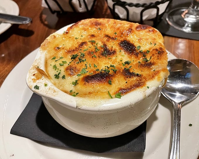 Golden-topped baked onion soup arrives bubbling like a cheese volcano ready to warm your soul.