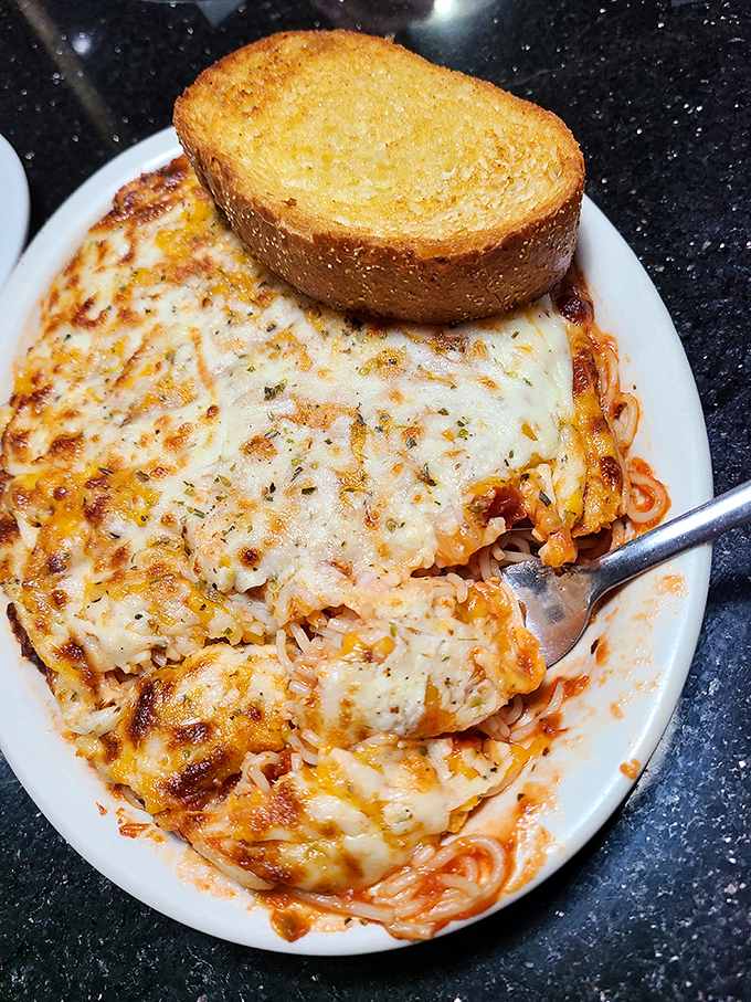 Cheese blankets for pasta! This baked spaghetti looks like it's tucked in for a cozy night under a golden comforter of melted mozzarella and garlic toast.