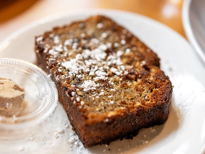 Golden-brown banana bread dusted with powdered sugar—proof that sometimes the simplest pleasures are worth crossing county lines for.