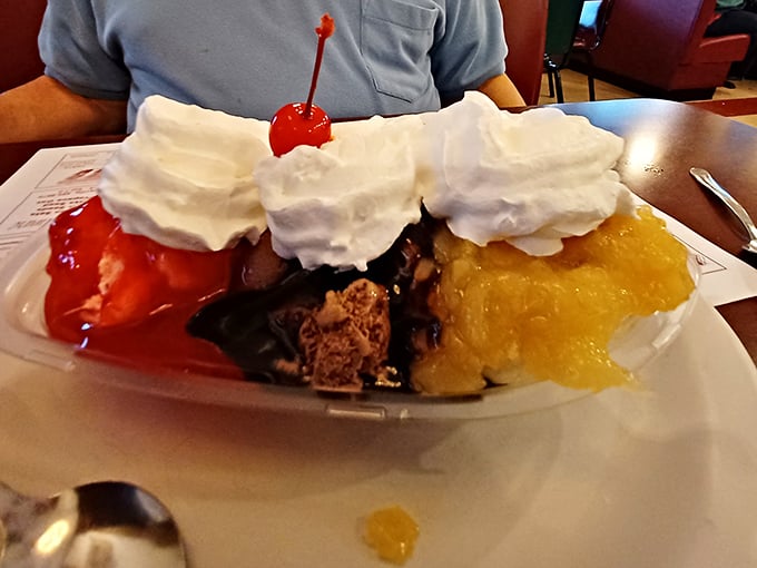 Three distinct ice cream flavors crowned with whipped cream mountains and a cherry sentinel—dessert architecture at its finest.