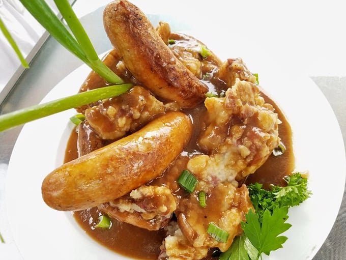 Bangers and mash swimming in rich onion gravy – comfort food that hugs you from the inside like a warm British cardigan.