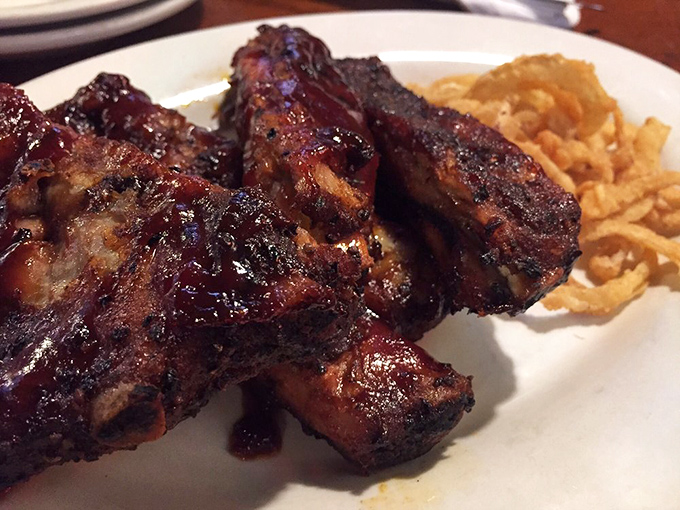 These ribs aren't falling off the bone—they're clinging to it just enough to remind you that proper barbecue requires a little work.