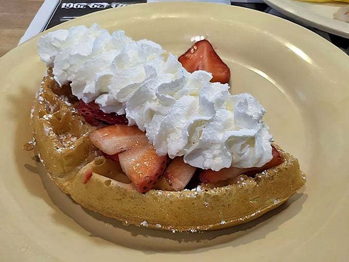 This Belgian waffle topped with strawberries and whipped cream isn't just breakfast – it's dessert with morning permission slip attached.