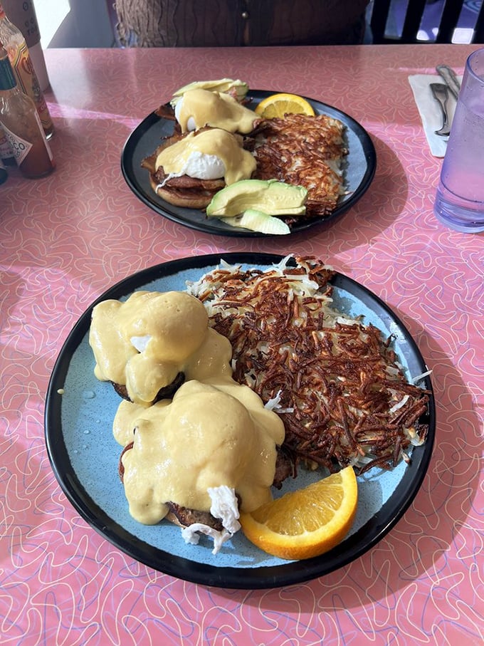 Eggs Benedict done right—hollandaise cascading like a golden waterfall over English muffins. Crispy hash browns standing guard on the side.