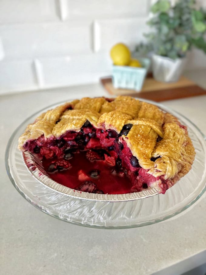 This berry pie isn't just dessert; it's edible art with a perfect lattice crust barely containing a volcanic eruption of summer berries.