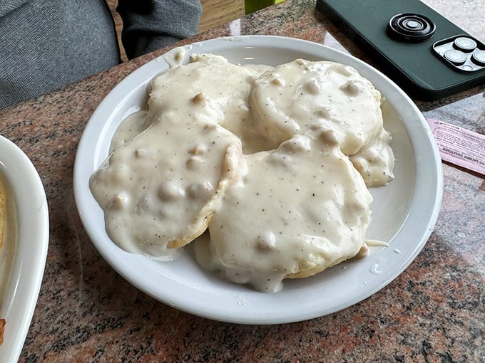 These biscuits and gravy aren't messing around—they're smothered in a peppery blanket that would make any Southern grandmother nod in approval.