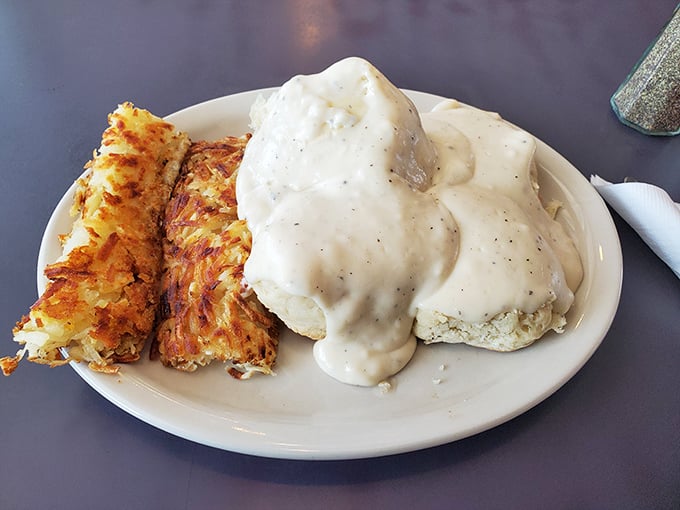 Another breakfast masterpiece: biscuits drowning in creamy gravy with crispy potatoes standing guard on the side.