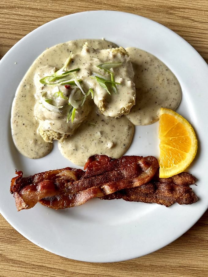 Biscuits swimming in gravy with green onion lifeguards – a breakfast that says "go back to bed after this, you've earned it."