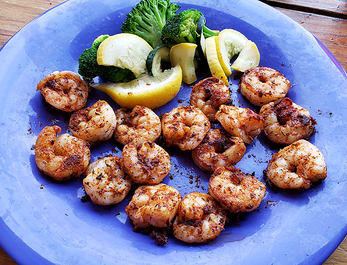 Perfectly seasoned shrimp surround fresh vegetables like delicious sentinels guarding the gateway to seafood happiness.