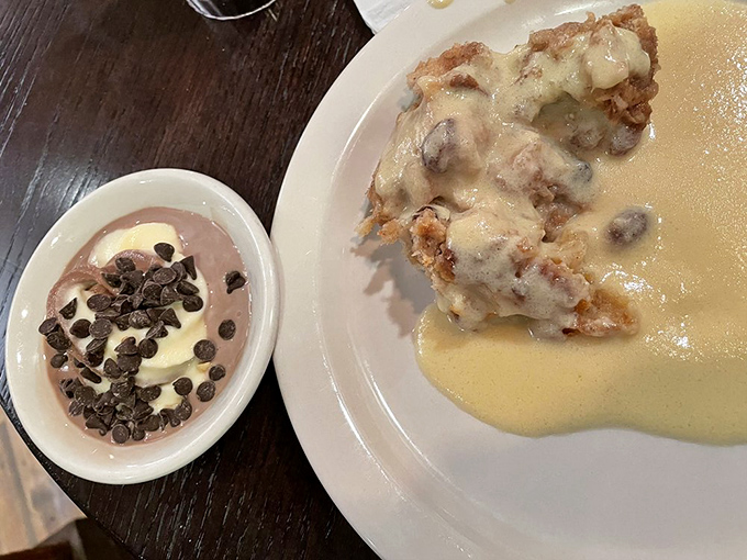 Bread pudding swimming in vanilla sauce alongside chocolate-topped pudding—proof that the best relationships are sweet, rich, and slightly indulgent.