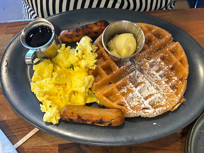 Breakfast perfection on a plate: golden waffles, fluffy scrambled eggs, and sausage links that make hitting the snooze button seem like a crime against humanity.
