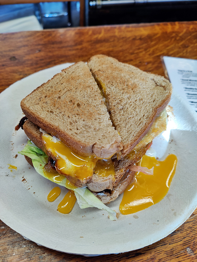 This breakfast sandwich isn't just leaking yolk—it's sharing joy. The kind of messy goodness that makes Monday mornings bearable.