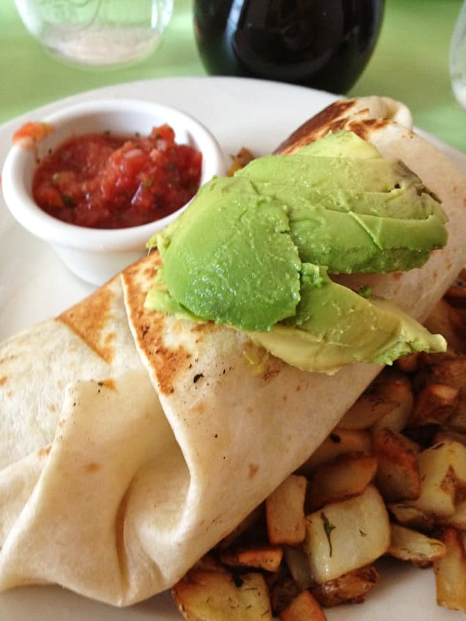 Breakfast burritos should always look this good—stuffed with goodness, crowned with avocado, and served with a side of morning happiness.