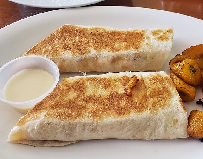 The breakfast burrito – perfectly grilled to a gentle crisp – sits like a gift-wrapped package of morning deliciousness alongside seasoned potatoes.