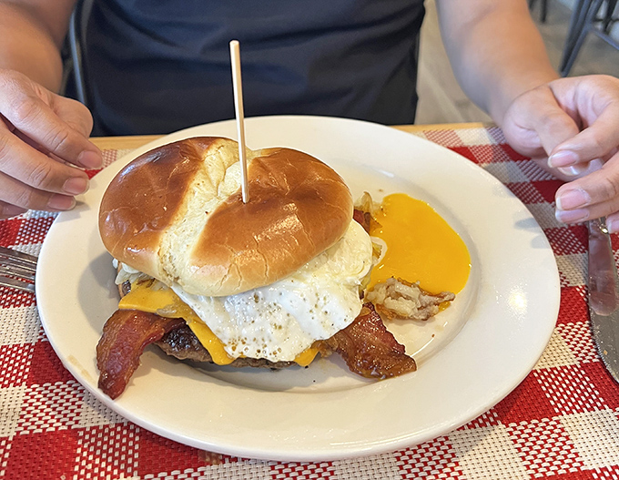 Behold the breakfast burger in all its glory—where brioche, bacon, and a perfectly fried egg create the holy trinity of morning indulgence.