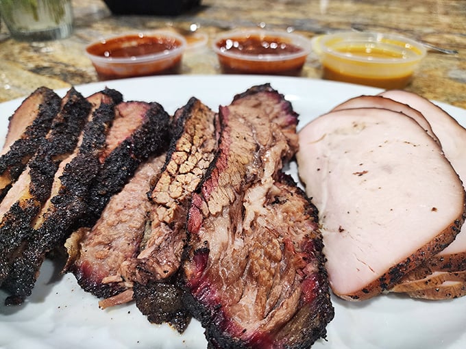 Brisket with that telltale pink smoke ring and turkey sliced thin—proof that patience and wood smoke create culinary magic.
