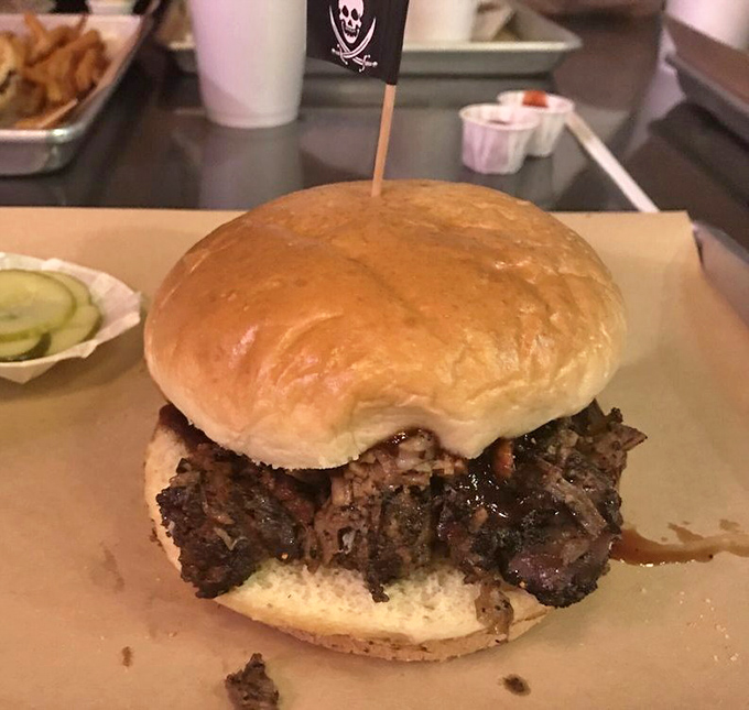 The pirate flag isn't just for show—this sandwich has conquered many a hungry sailor with its mountain of smoky brisket nestled in a pillowy bun.