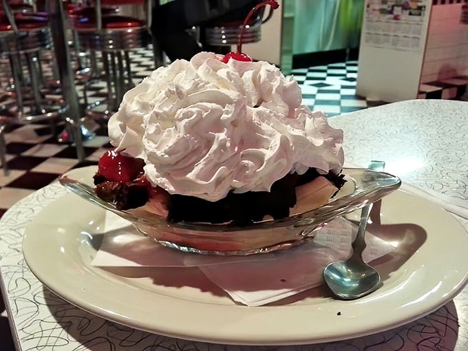 Whipped cream mountains with cherry summits—this brownie banana split has its own topography that demands to be explored one spoonful at a time.