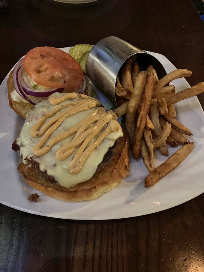 This isn't just a burger, it's an architectural achievement—melty cheese cascading down beef with fries standing at attention, ready for duty.