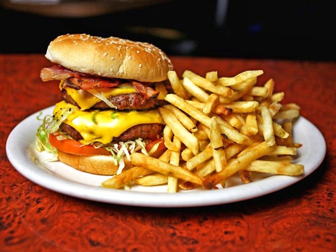 The burger arrives like a beautiful, beefy monument to excess. Those golden fries aren't a side dish—they're co-stars in this delicious production.