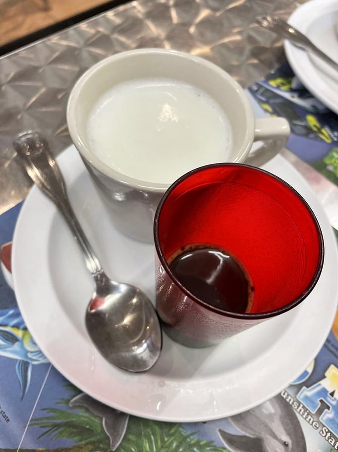 The café con leche arrives with its faithful sidekick—a shot of Cuban coffee that packs more punch than a heavyweight champion.