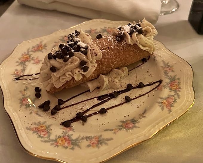 This cannoli isn't just dessert, it's architecture—a crisp shell fortress protecting creamy ricotta treasure, with chocolate chips standing guard at both ends.