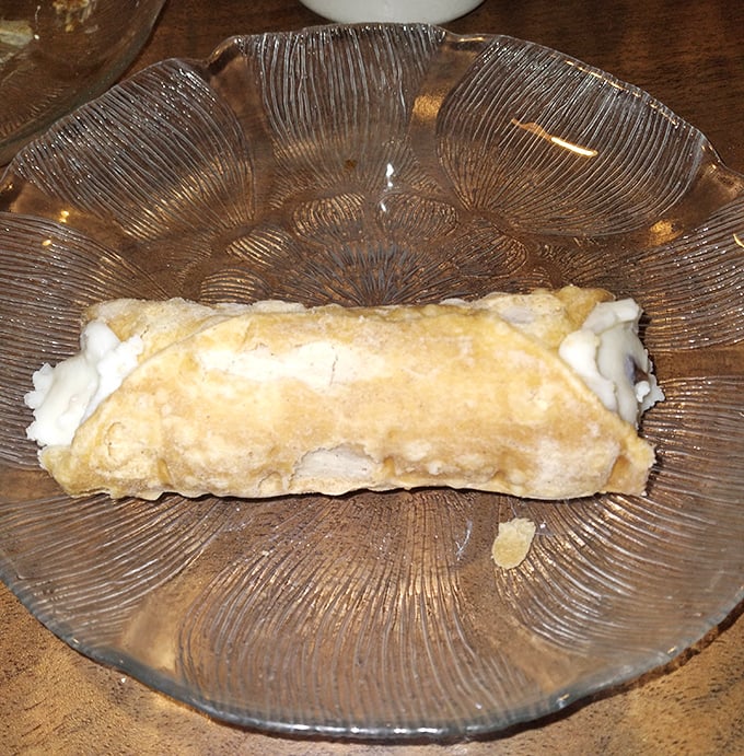 Not just a dessert, but a delicate achievement in pastry engineering—a crisp shell cradling sweet filling, served on a plate that's about to witness pure joy.