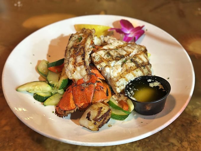 Grilled fish and lobster tail sharing a plate with fresh vegetables – proof that Florida seafood needs minimal intervention to shine.