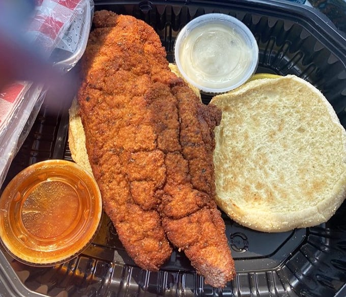 This isn't just a fish sandwich—it's a masterpiece of crispy, golden-brown catfish that's had a perfect spa treatment in seasoned breading before meeting its destiny on a soft bun.