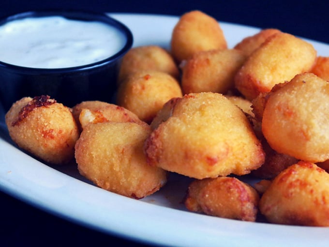 Wisconsin's unofficial state treasure—cheese curds fried to golden perfection. Like little nuggets of happiness that squeak with Midwestern pride.